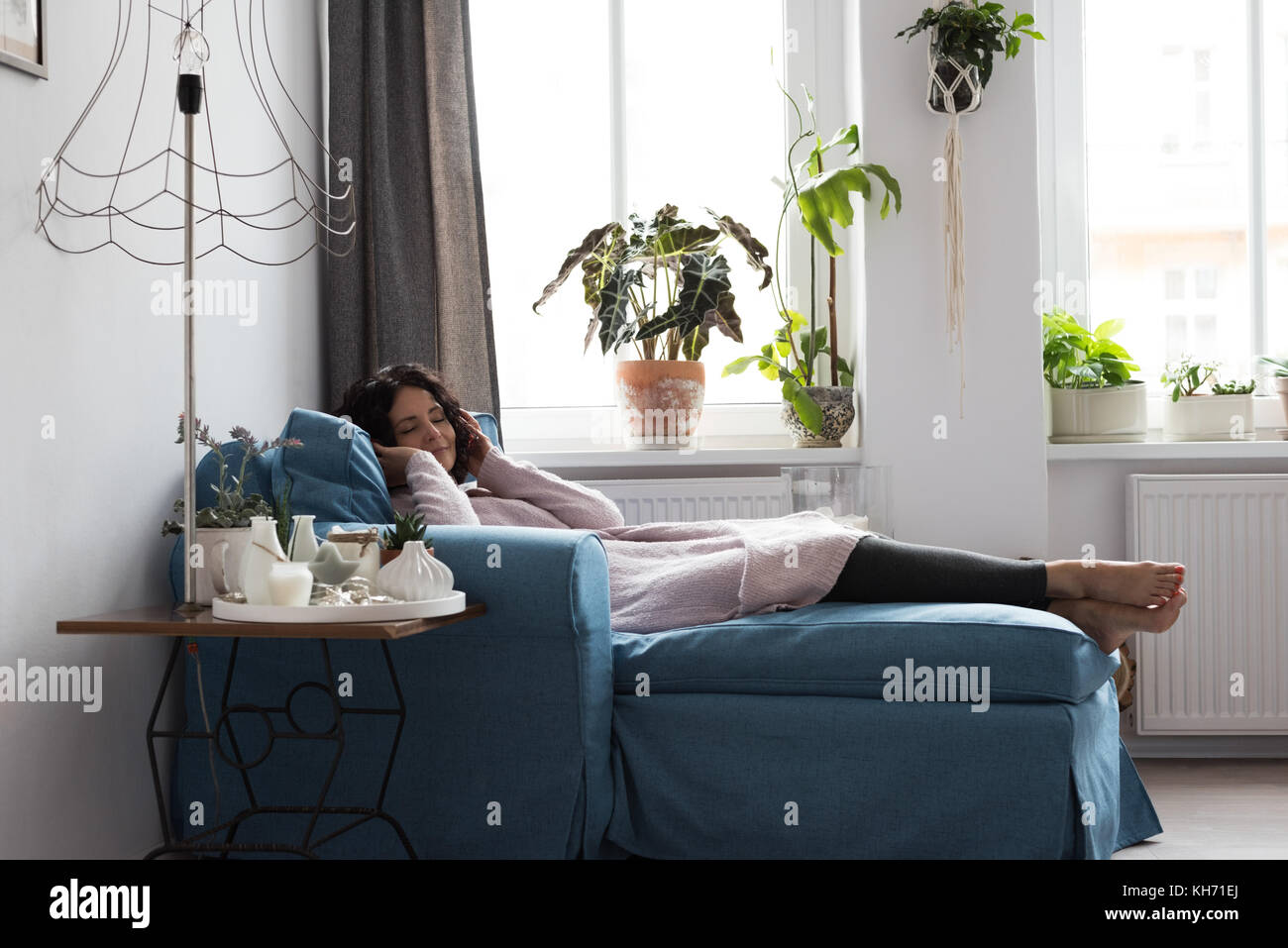 Beautiful woman resting on sofa at home Stock Photo - Alamy