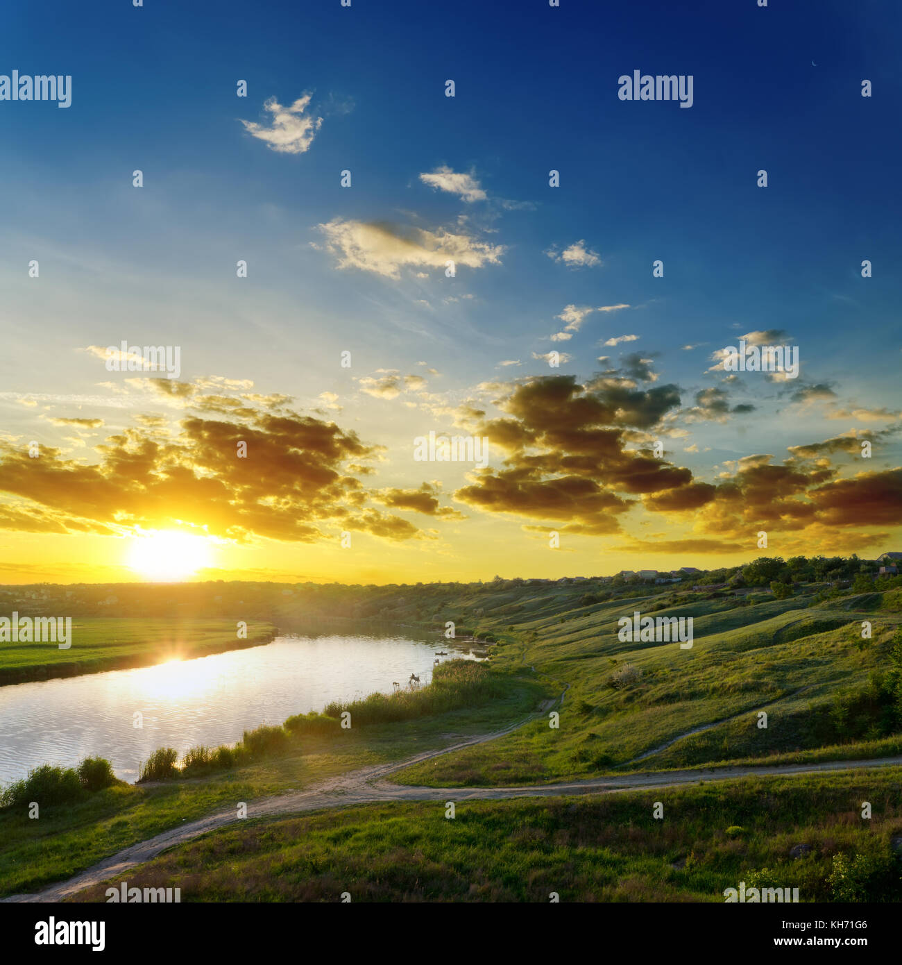 sun over river with dramatic sky Stock Photo - Alamy