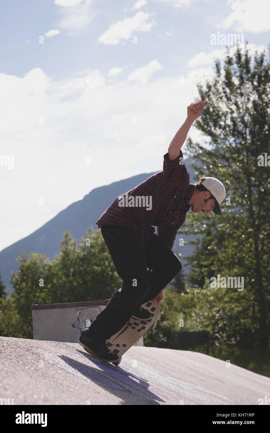 Skateboarder performing stunt on ramp in skate park Stock Photo - Alamy