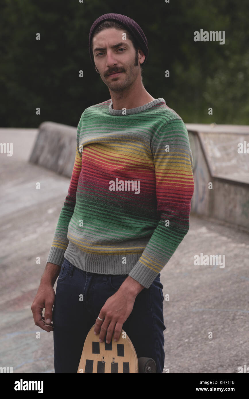 Portrait of man with skateboard standing in skate park Stock Photo - Alamy