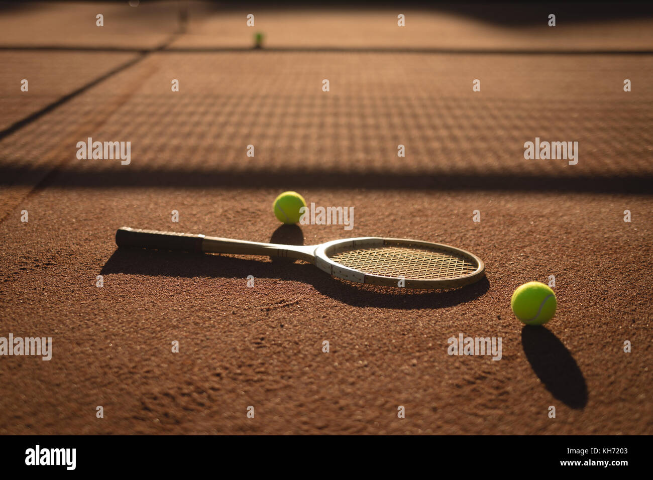 Tennis ball and racket in ground on a sunny day Stock Photo - Alamy