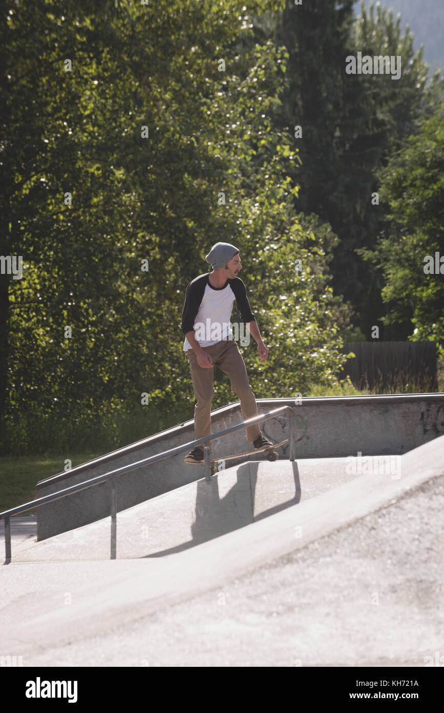Skateboarder performing stunt on ramp in skate park Stock Photo - Alamy
