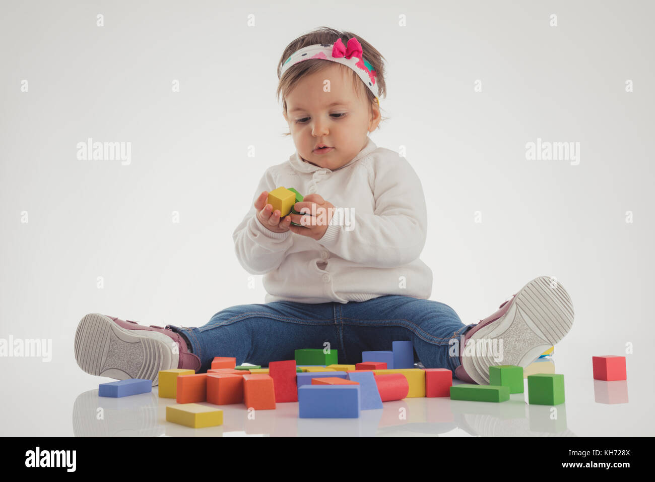 Cute baby girl playing wooden cubes isolated on white background Stock ...