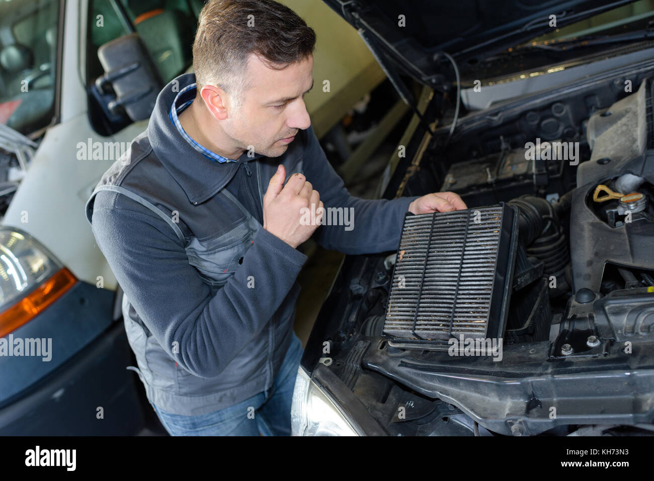 mechanic changing car air filter Stock Photo - Alamy