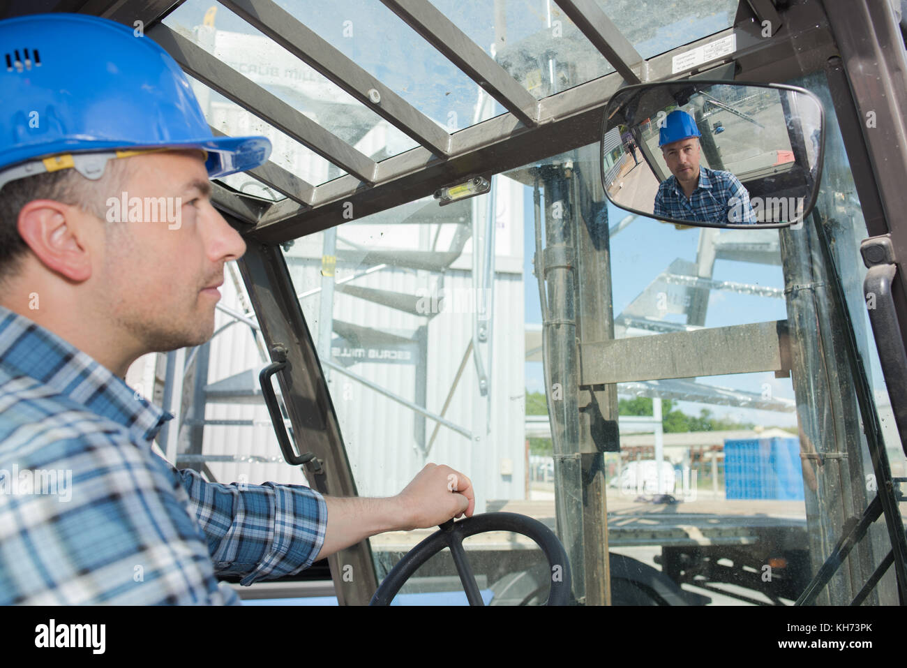 Forklift driver looking in rearview mirror Stock Photo - Alamy