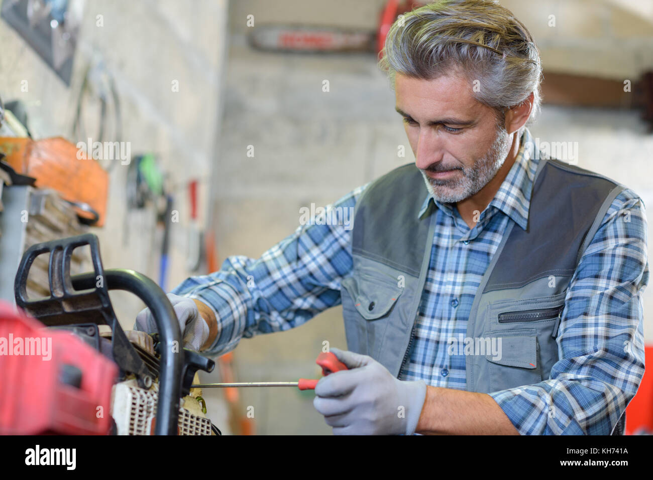 Mechanic working on gardening equipment Stock Photo - Alamy