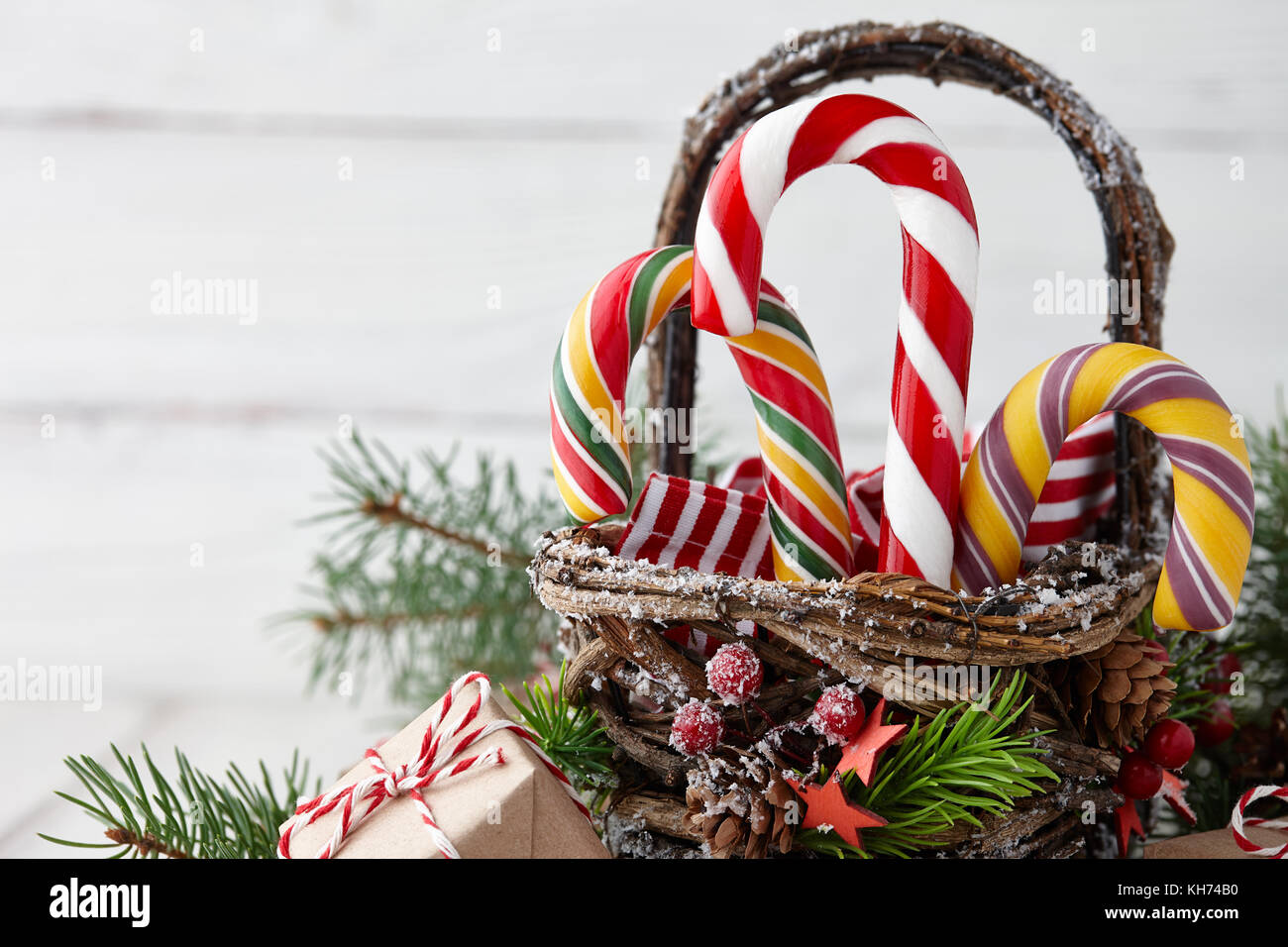 Christmas basket with candy canes on white planks Stock Photo - Alamy