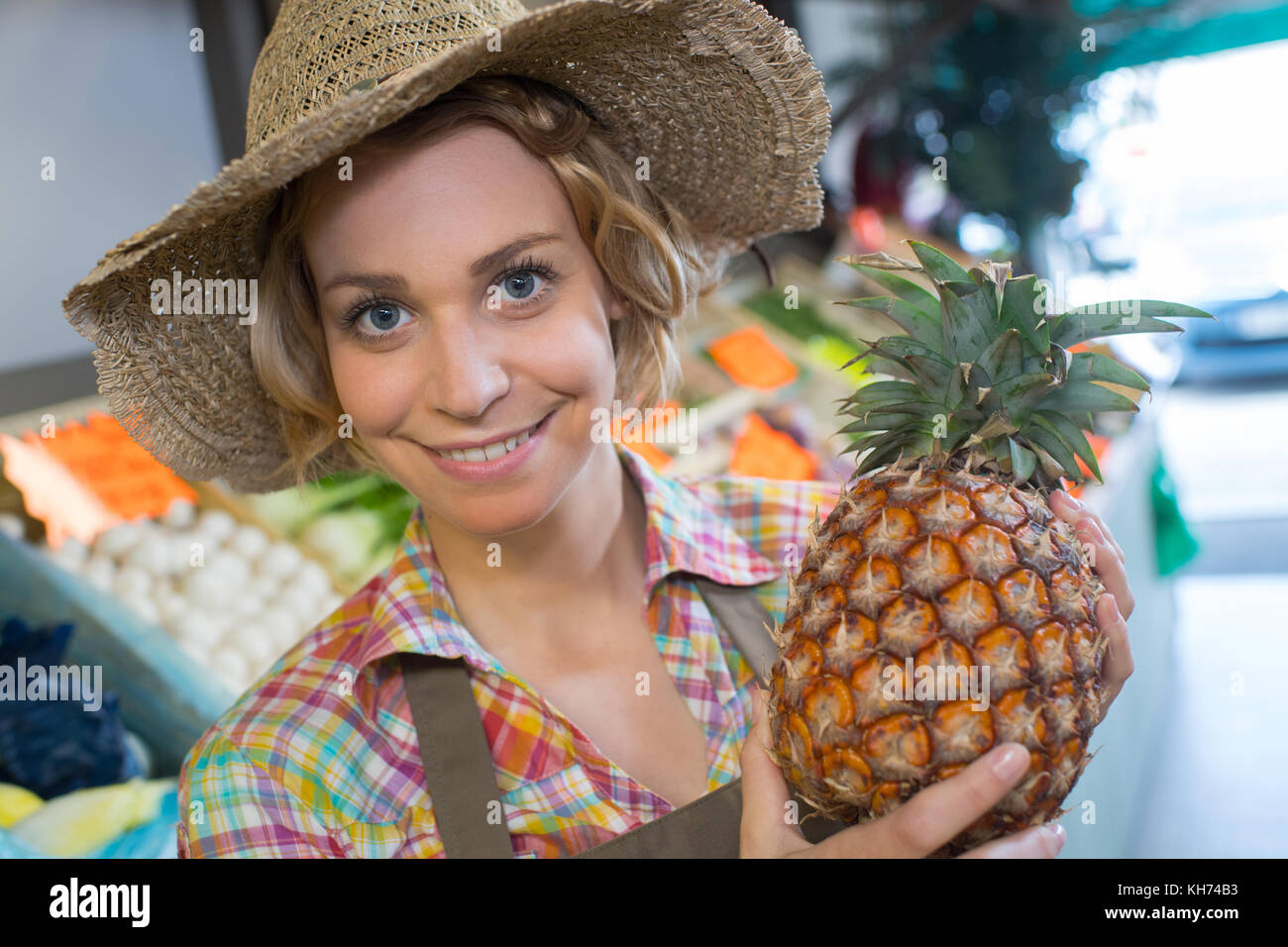 young happy woman in supermarket holding pineapple Stock Photo - Alamy