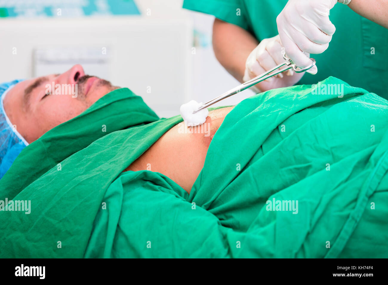 Surgeon in operating room with swab operating patient Stock Photo - Alamy