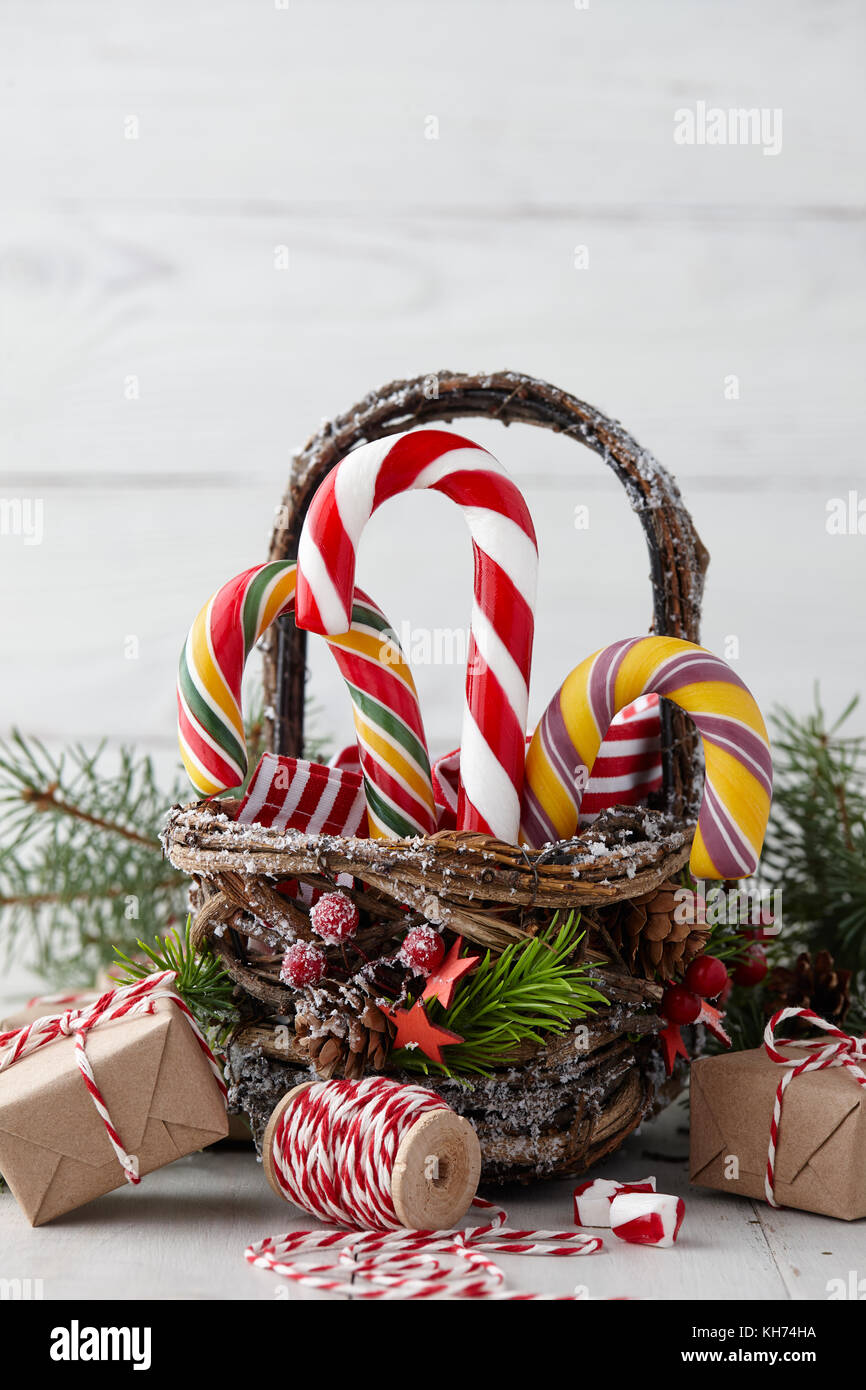 Christmas wicker basket with striped candy canes and gifts on white ...