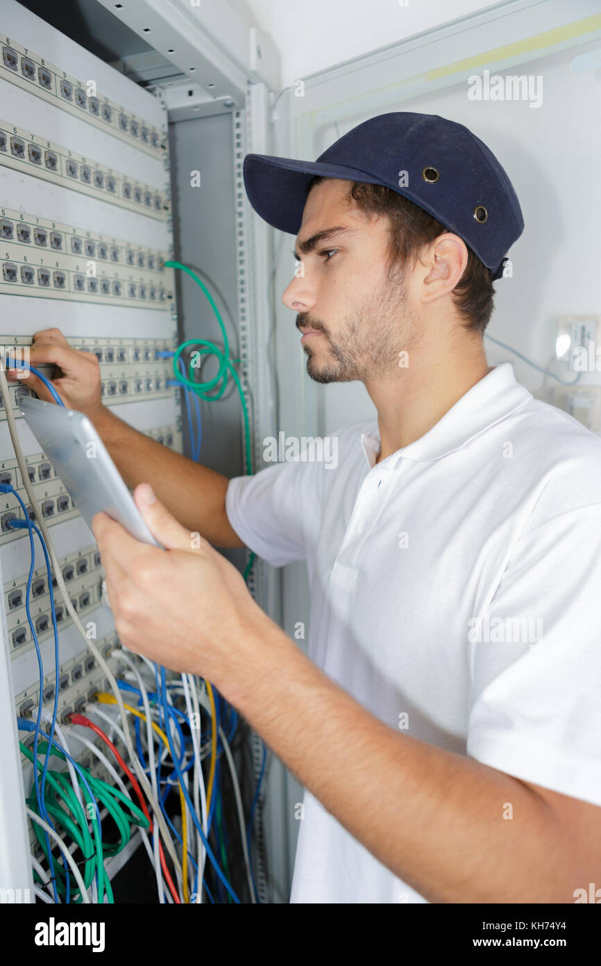 focused electrician applying safety procedure while working on ...
