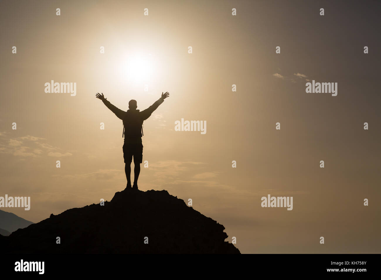Man with arms outstretched celebrating or praying in beautiful ...