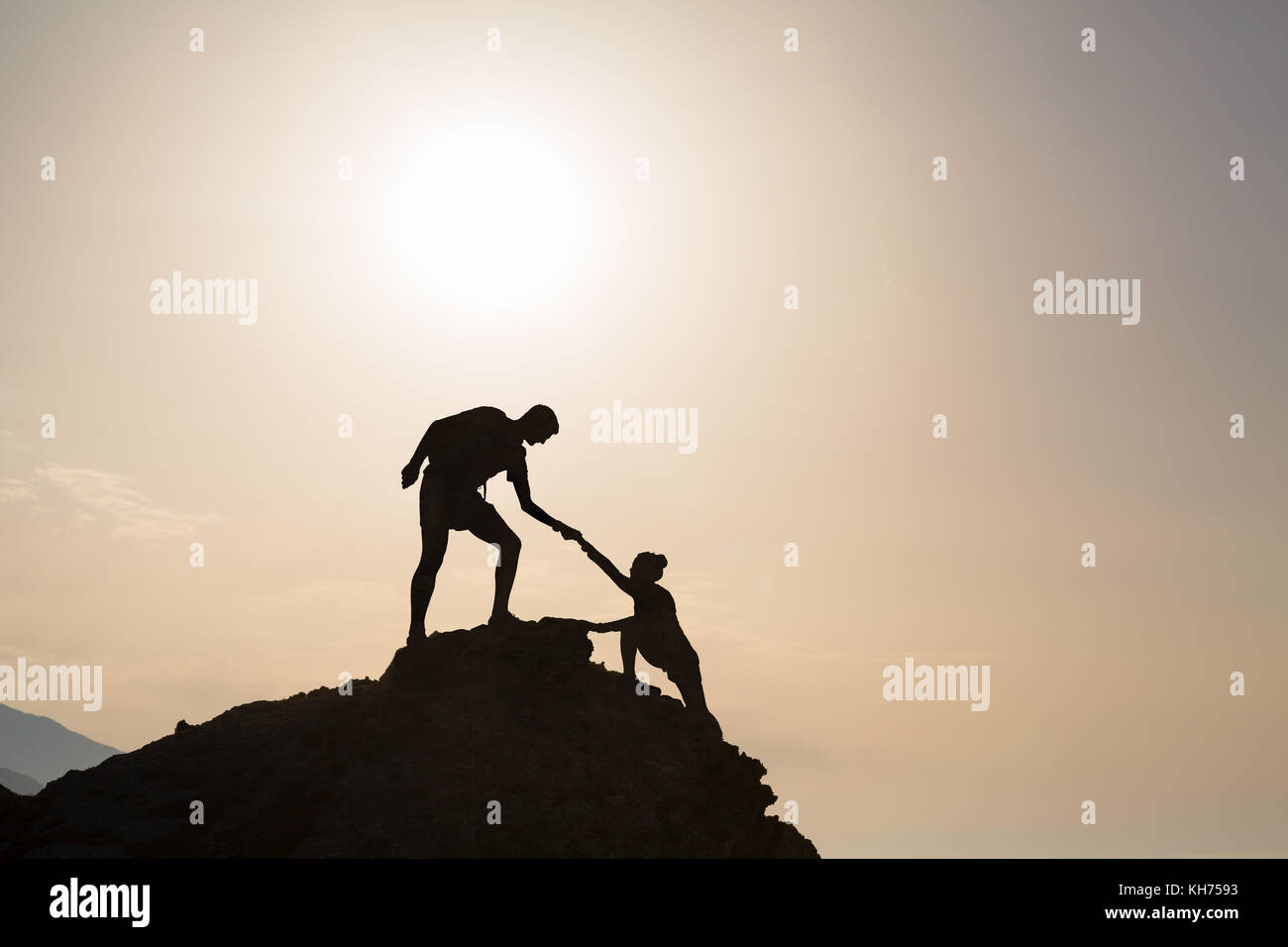 Silhouette man helping woman climb hi-res stock photography and images - Alamy