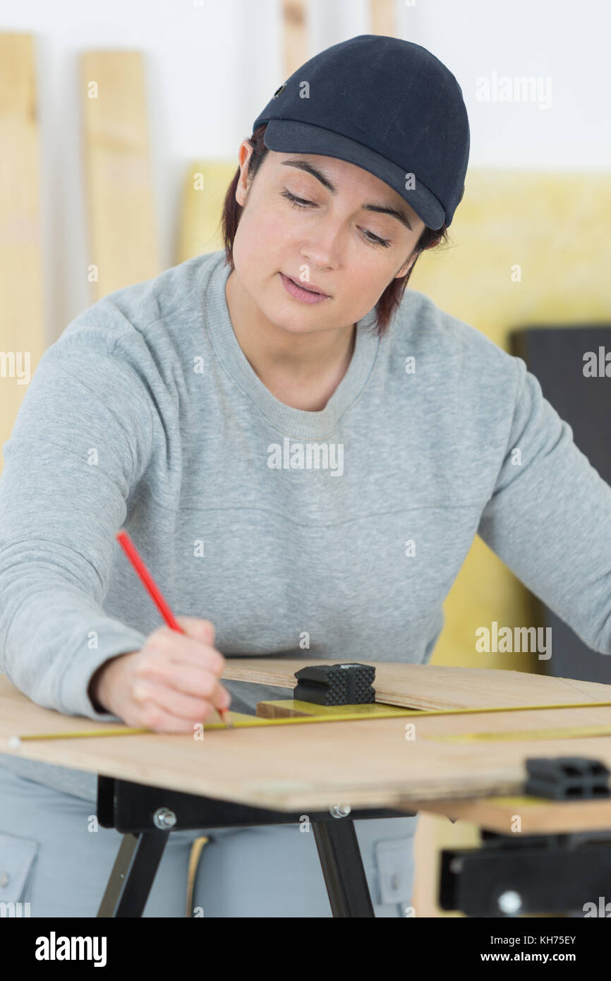 portrait of happy female woodworker drafting new project at workshop ...