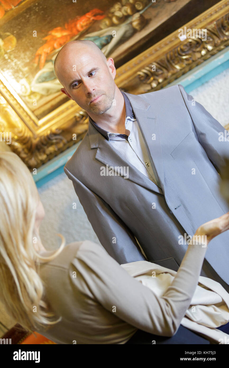 couple discussing painting in art gallery Stock Photo - Alamy