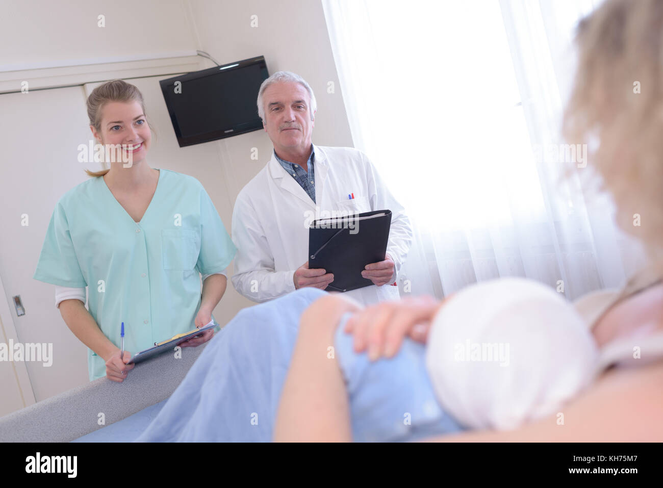doctor and nurse happy to see mum and newborn baby Stock Photo - Alamy
