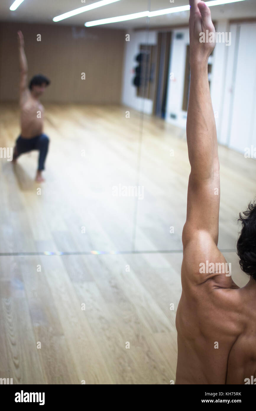 Man yoga teacher practising in gym fitness studio doing advanced asana ...