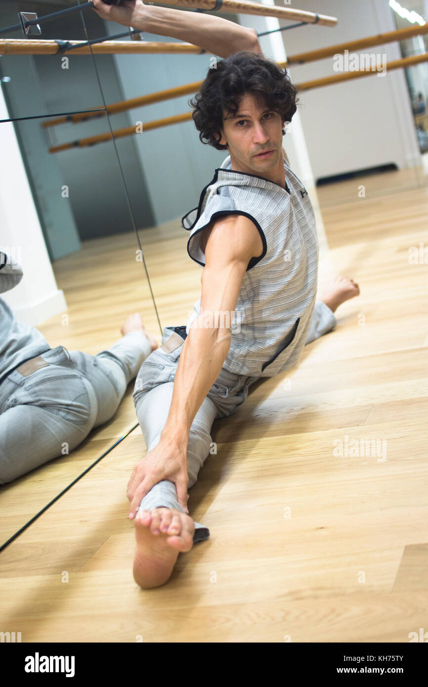 Man dancer dance teacher stetching in gym fitness studio doing advanced ...