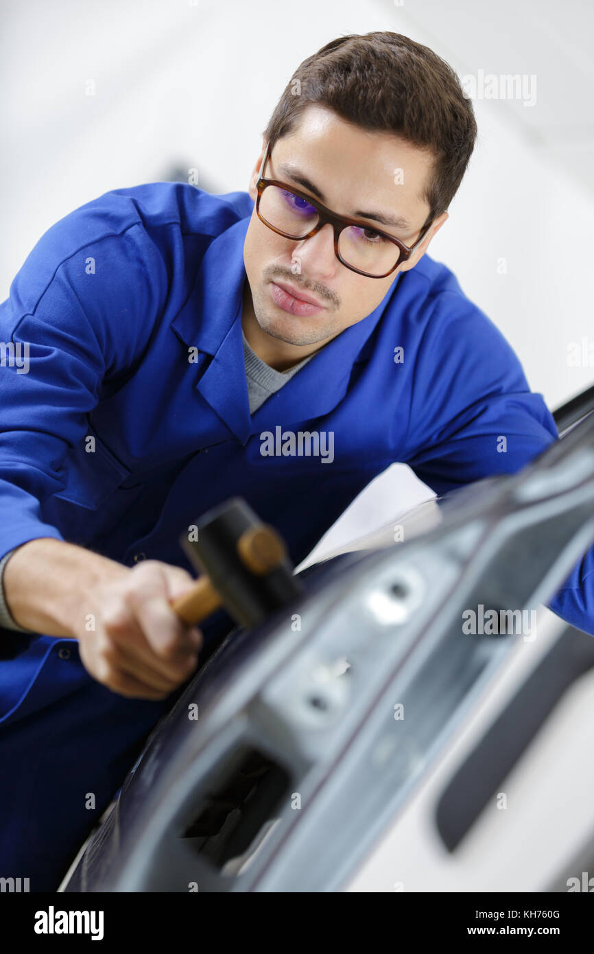 handsome mechanic in uniform repairing car door Stock Photo - Alamy
