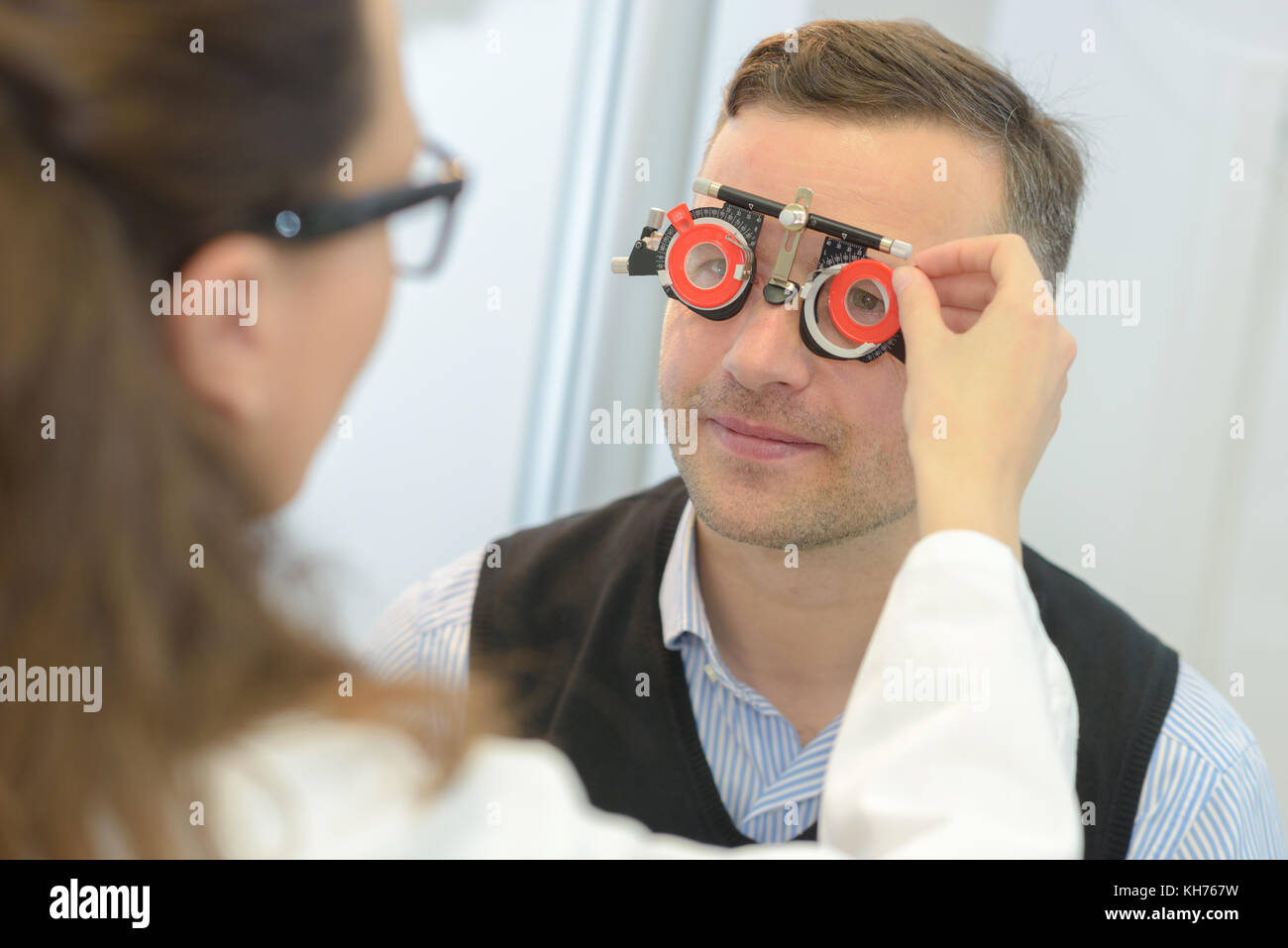 Optician fitting lens into testing glasses Stock Photo - Alamy