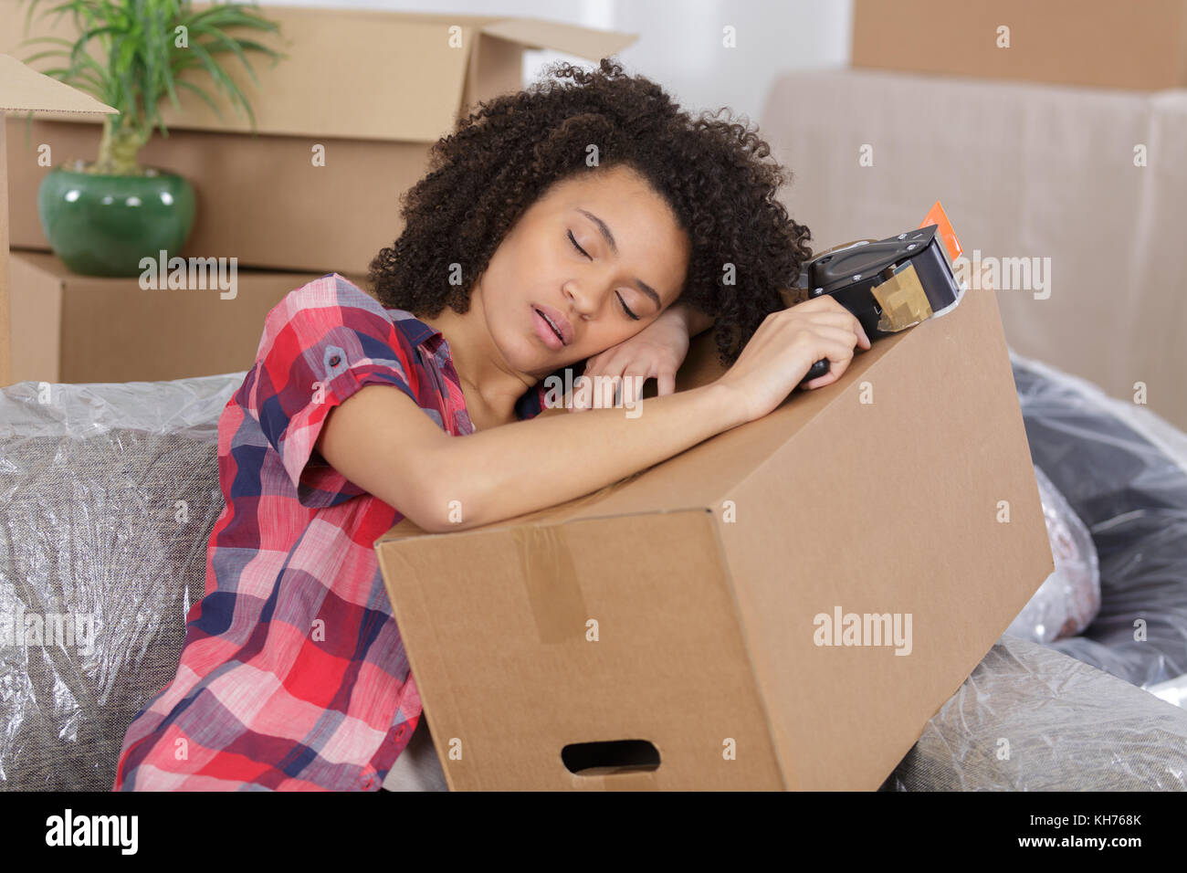 woman sleeping over package for house moving Stock Photo - Alamy