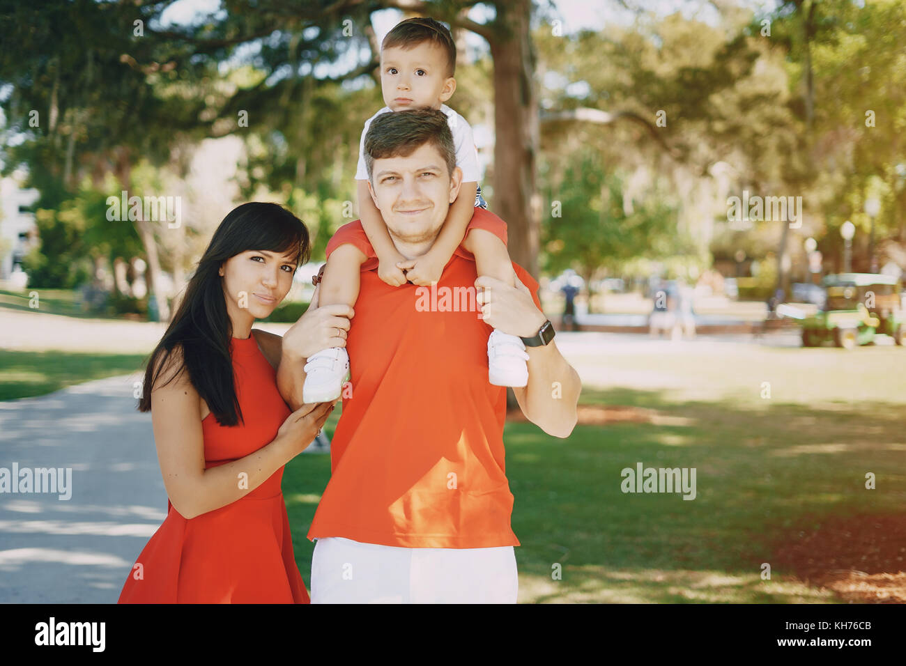 beautiful family in red walking down the street and the Park Stock ...
