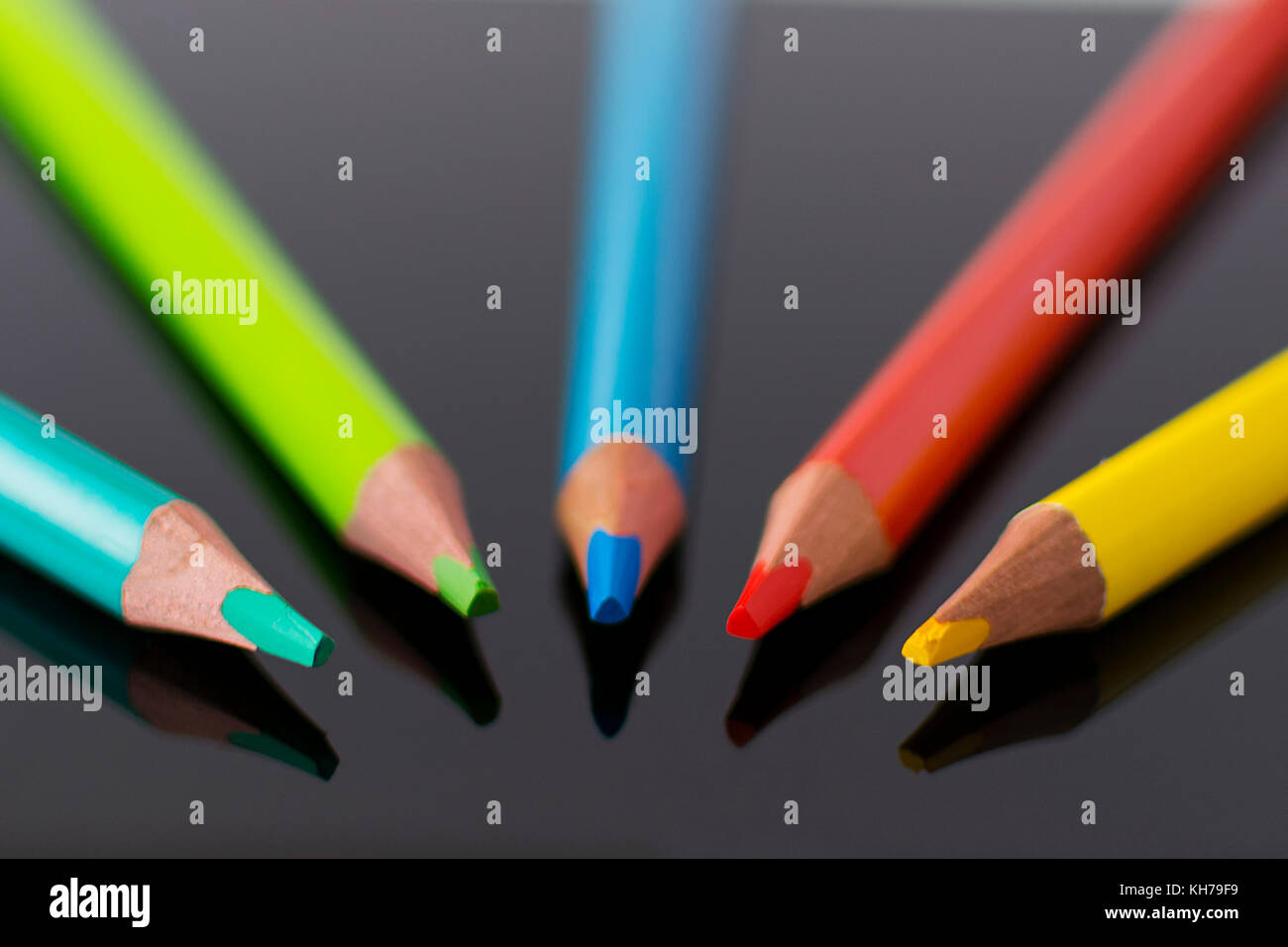 Multicolor pencils forming a semicircle with reflection on black ...