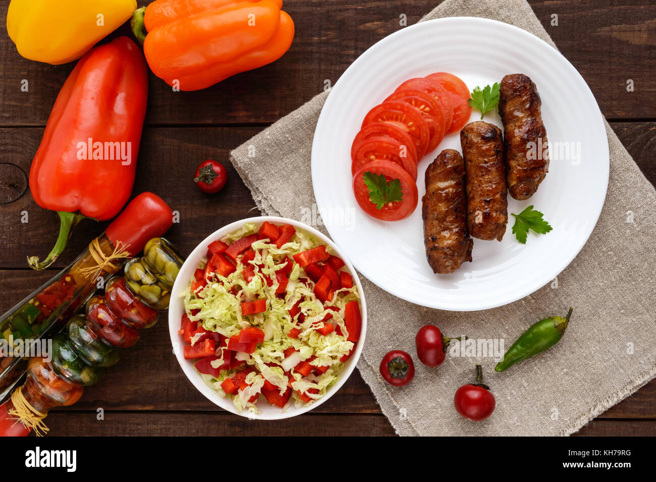 Juicy grilled rolls of minced meat wrapped in bacon with fresh tomato ...