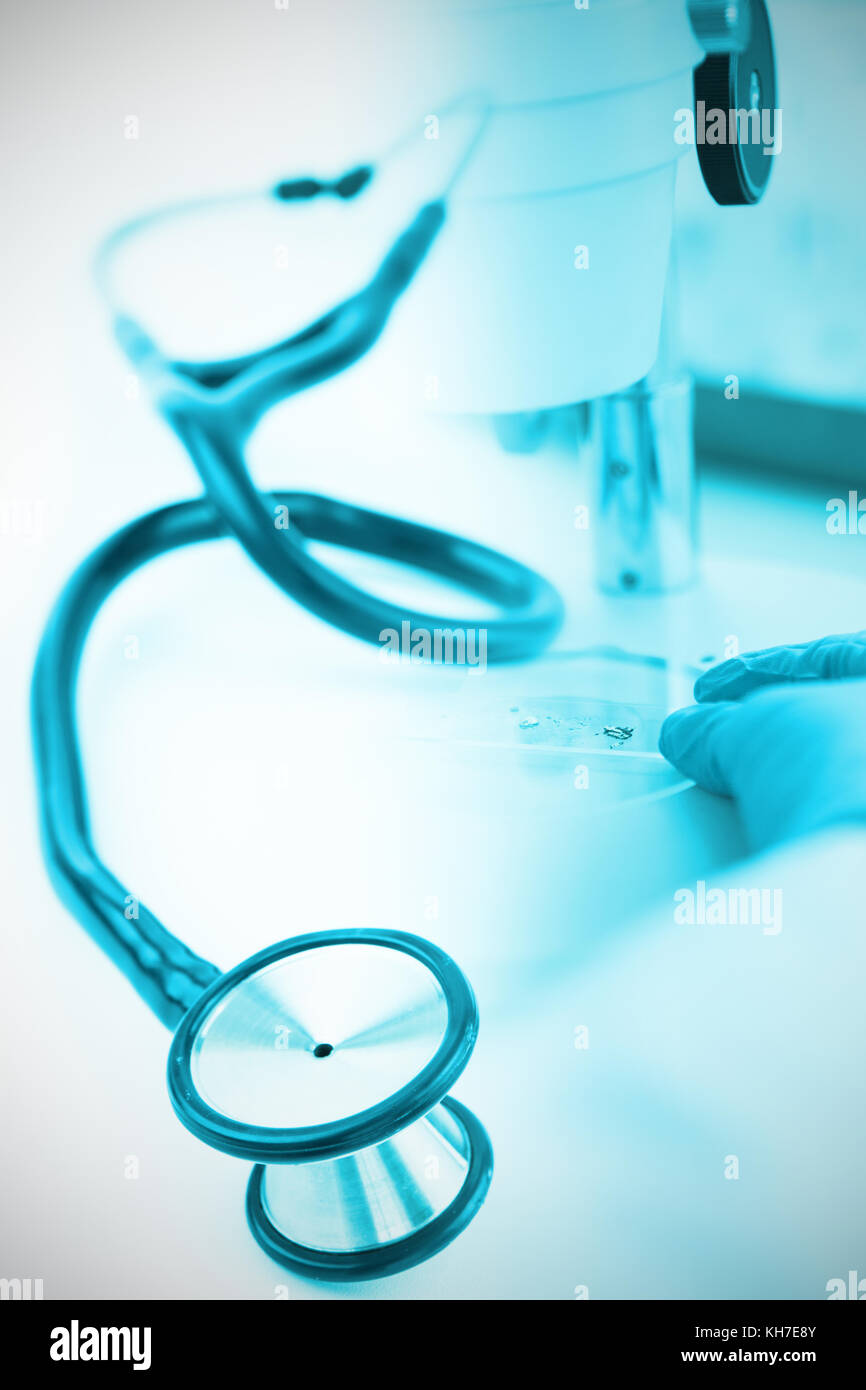 Blue stethoscope against doctor using microscope in laboratory Stock ...