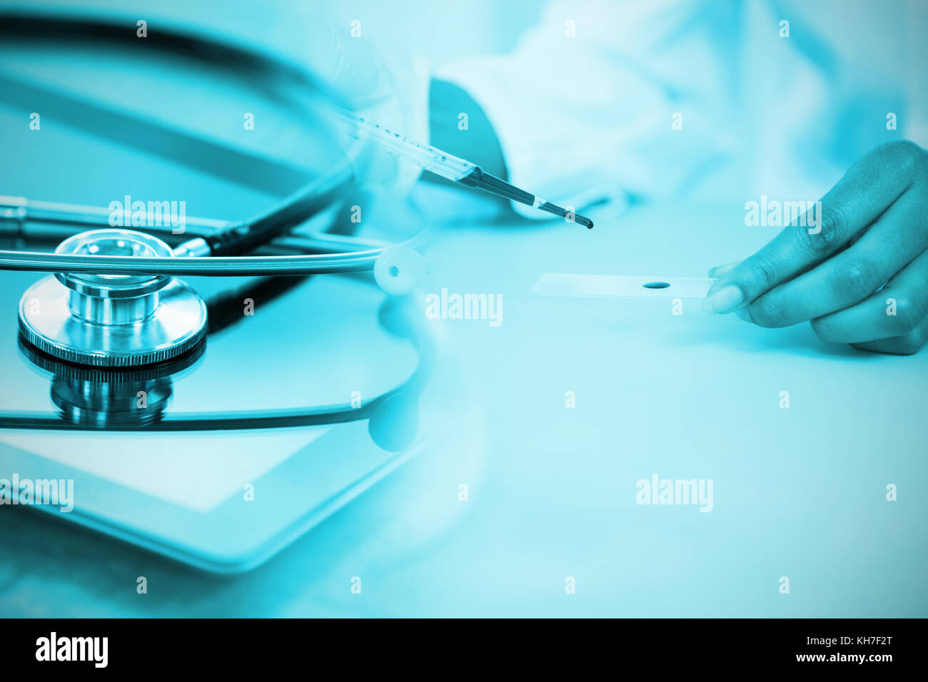 Stethoscope on digital tablet against technician doing blood test Stock ...