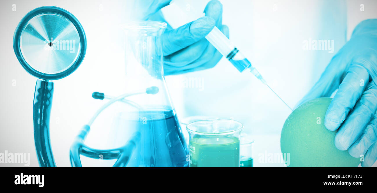 Blue stethoscope against doctor injecting an orange Stock Photo - Alamy