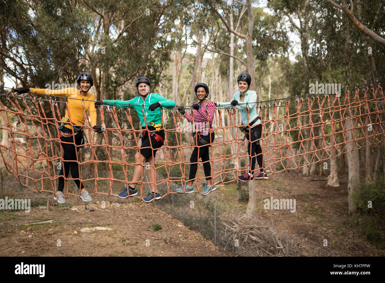 Portrait of happy friends walking on rope bridge Stock Photo - Alamy