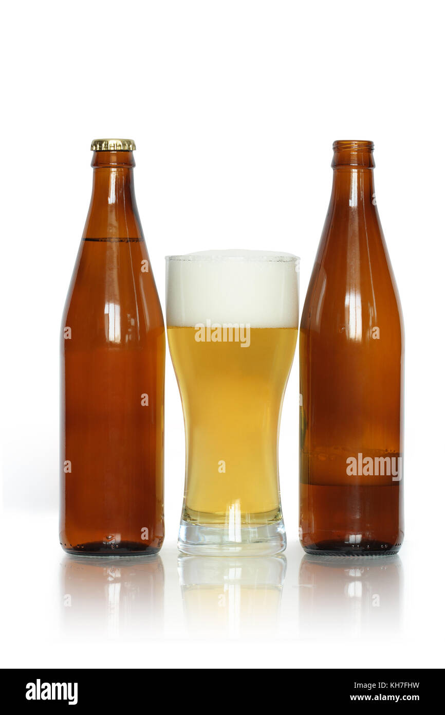 Glass of lager beer near two bottles isolated on white background with ...