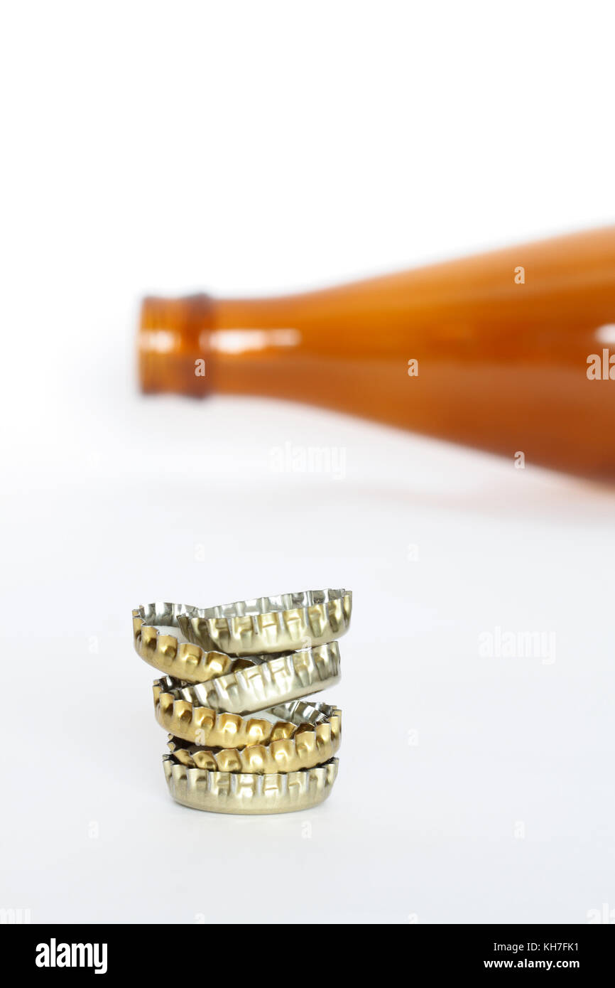 Stack of bottle caps on white background with lying empty bottle Stock ...