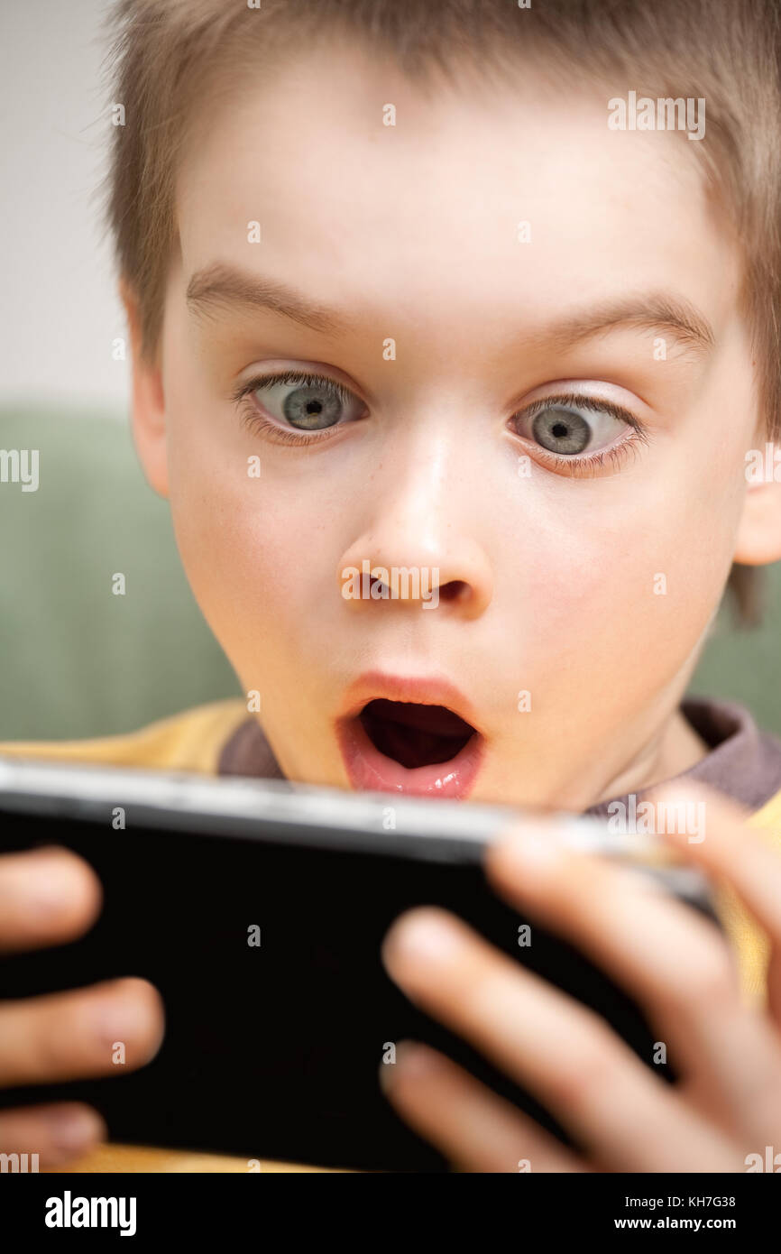 Young boy playing handheld game console Stock Photo - Alamy