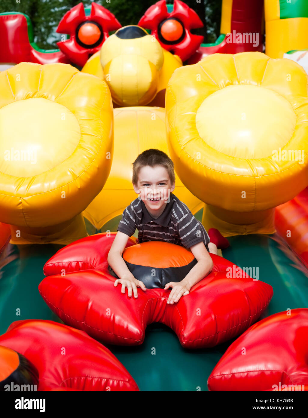 Young boy playing in inflatable playground Stock Photo - Alamy