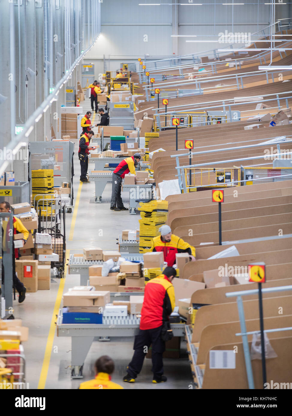 German Post DHL parcel couriers working in a delivery centre in ...