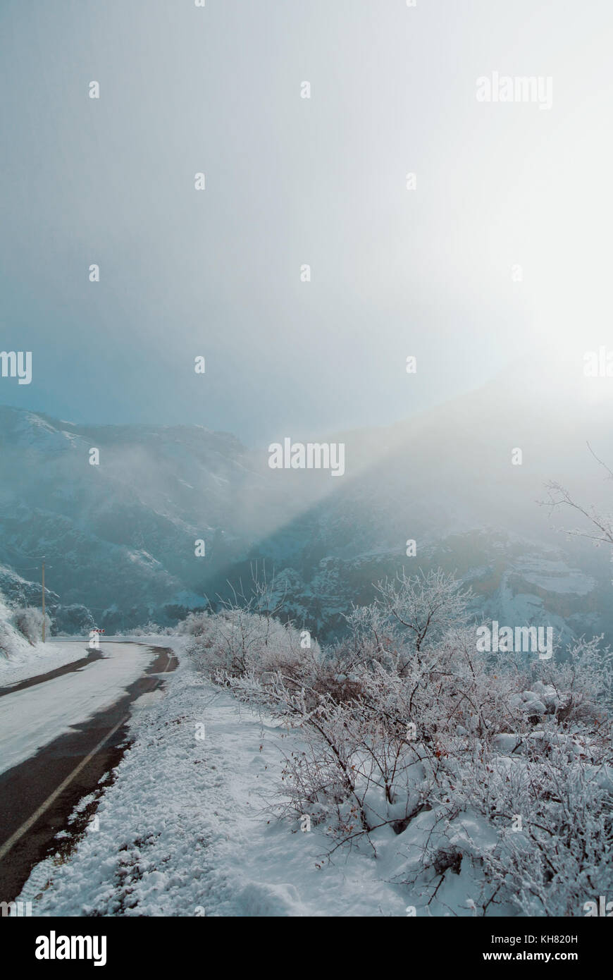 A dangerous winter serpentine road with attention signs covered with ...