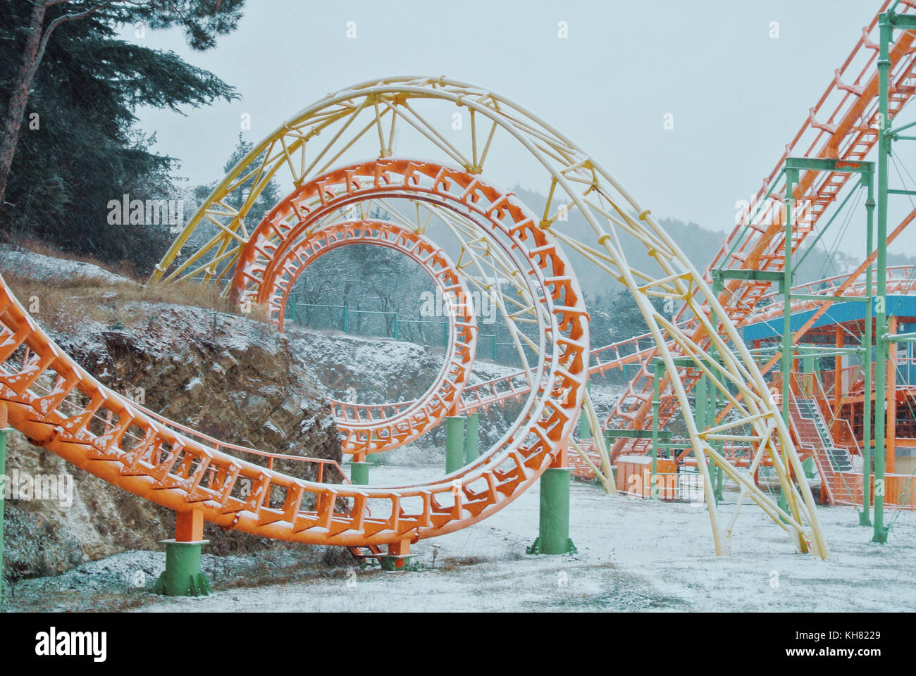Abandoned amusement theme park covered with falling snow on a cold ...