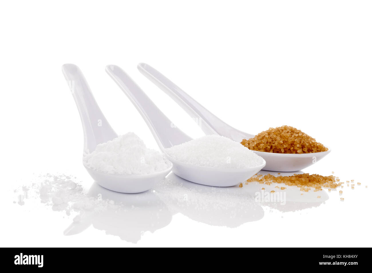Various types of sugar, brown, white and powdered sugar on spoons ...