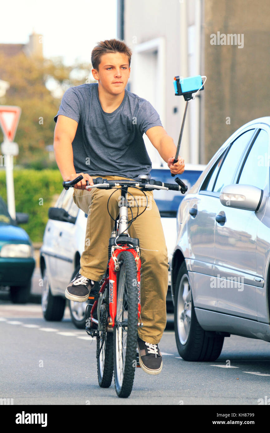 France, teenager using telescopic pole to film himself or photograph ...