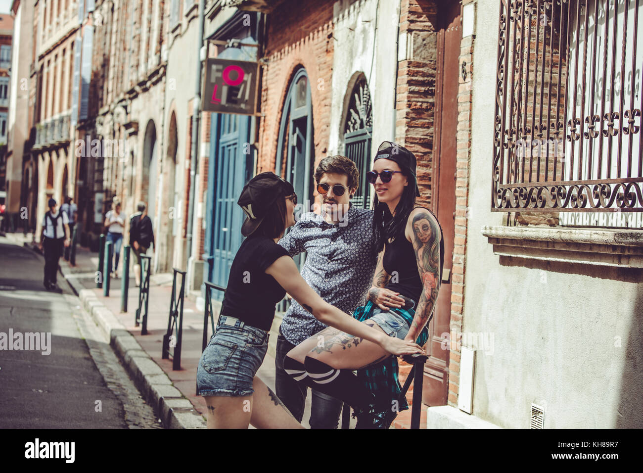 Three young people chatting in the street, cityscape Stock Photo - Alamy