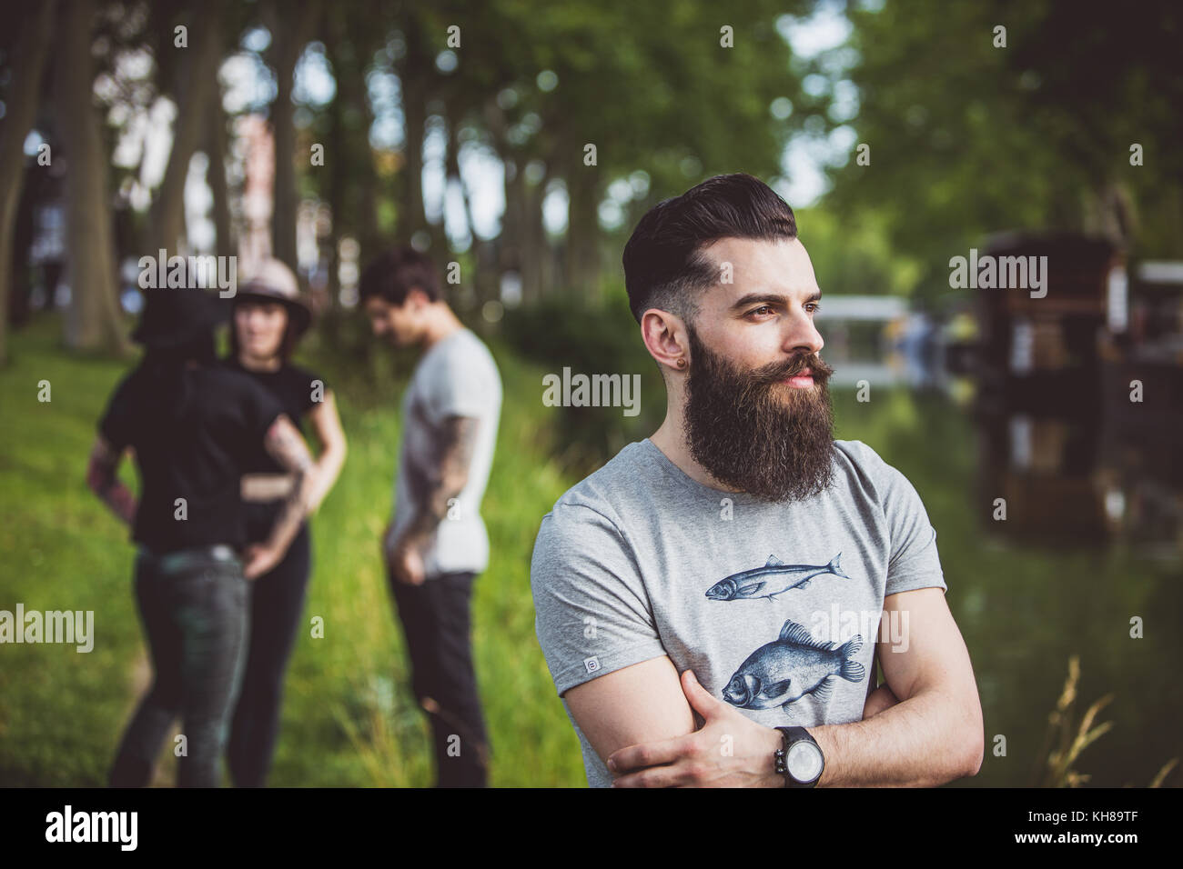 Portrait of a young man on the banks of the Garonne river barges and ...