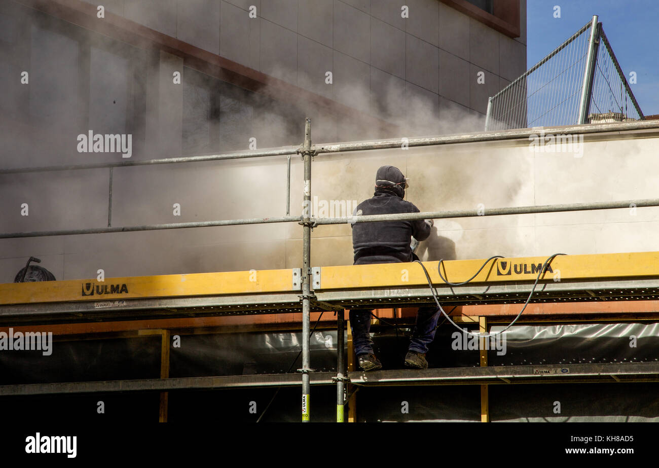 Worker on a building facade restoration Stock Photo - Alamy