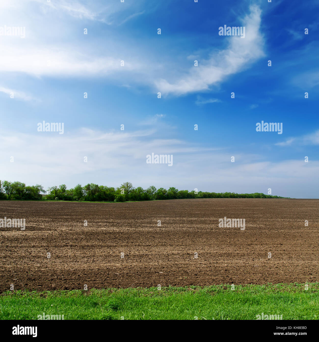 black spring field and cloudy sky Stock Photo - Alamy