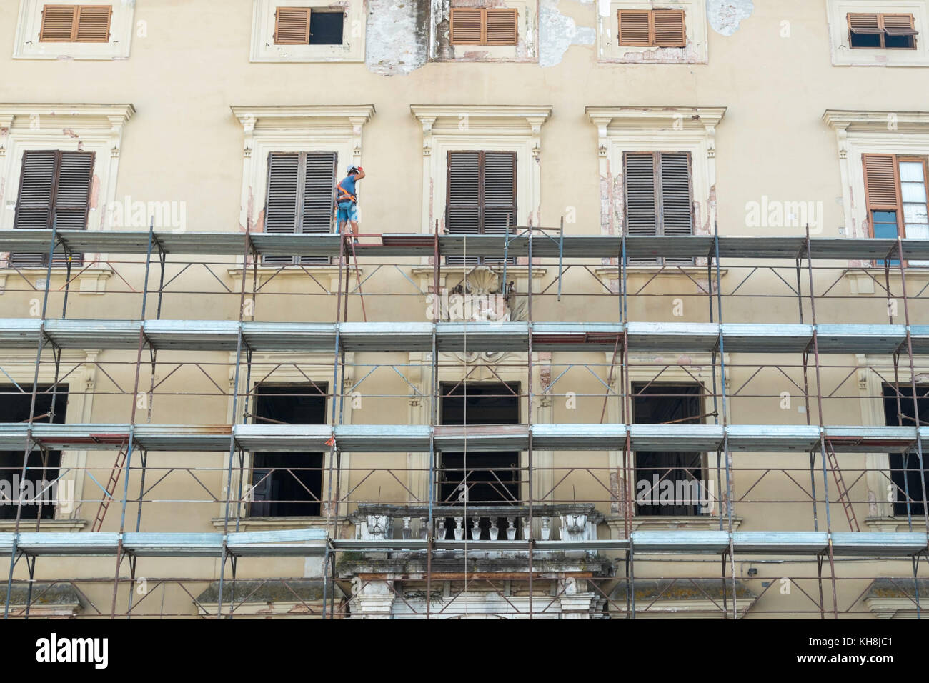 A builder walking along scaffolding in Lucca, Tuscany, Italy Stock ...