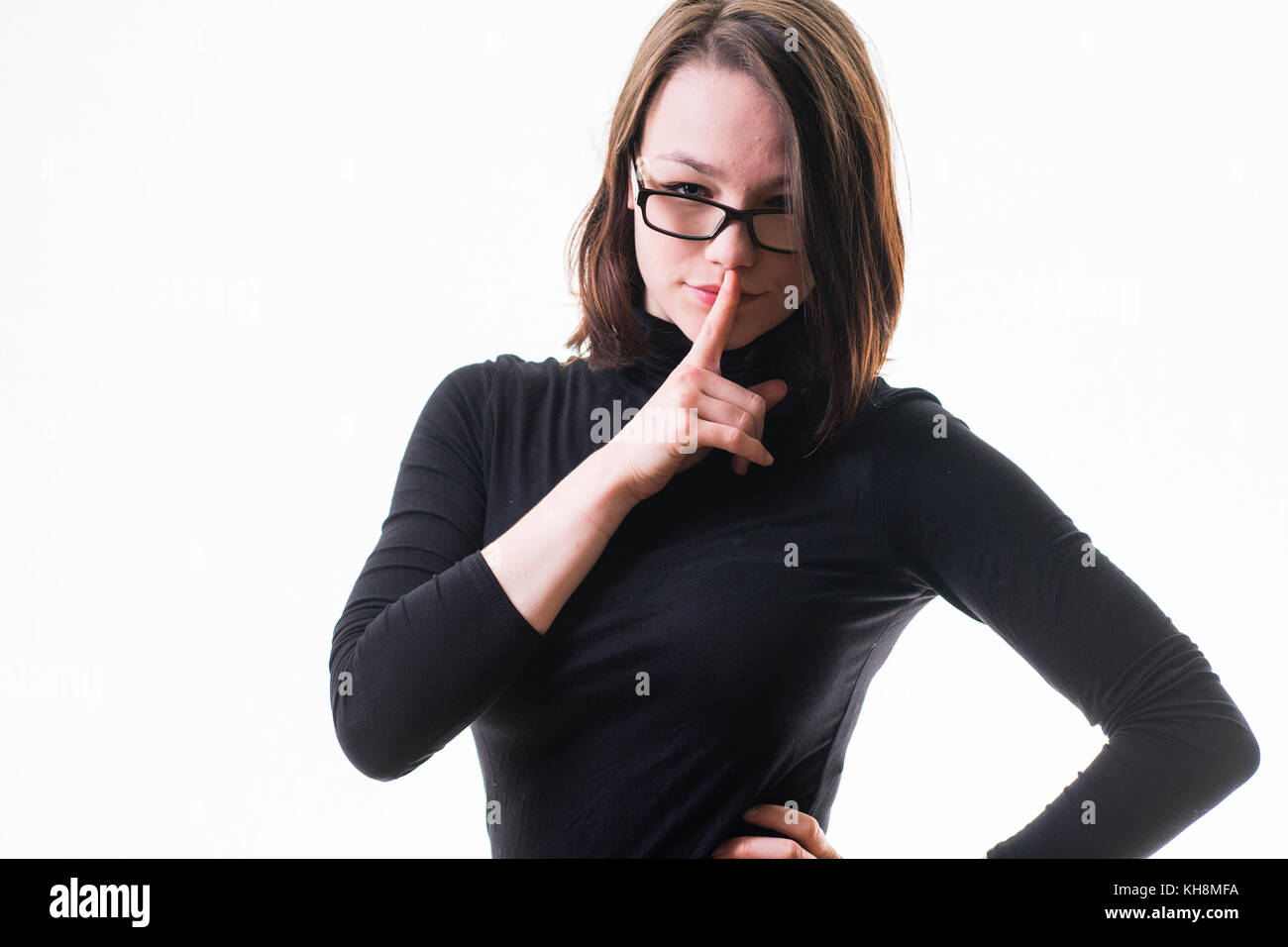Keeping a secret: A young brown haired caucasian teenage girl hushing ...