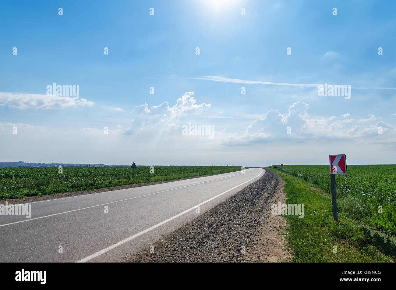 asphalt road under cloudy sky with sun Stock Photo - Alamy