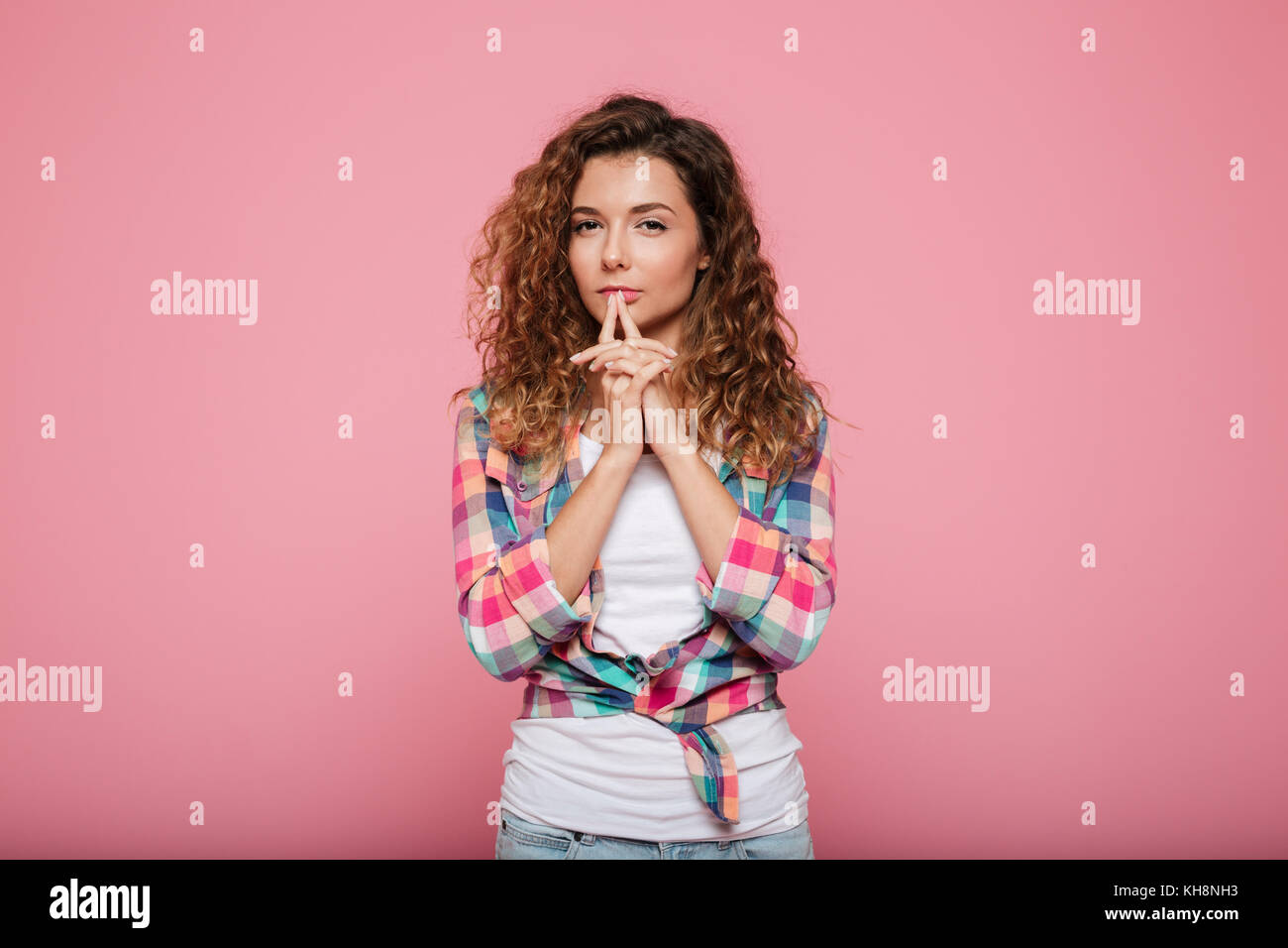 Thoughtful tricky woman looking camera isolated over pink Stock Photo ...