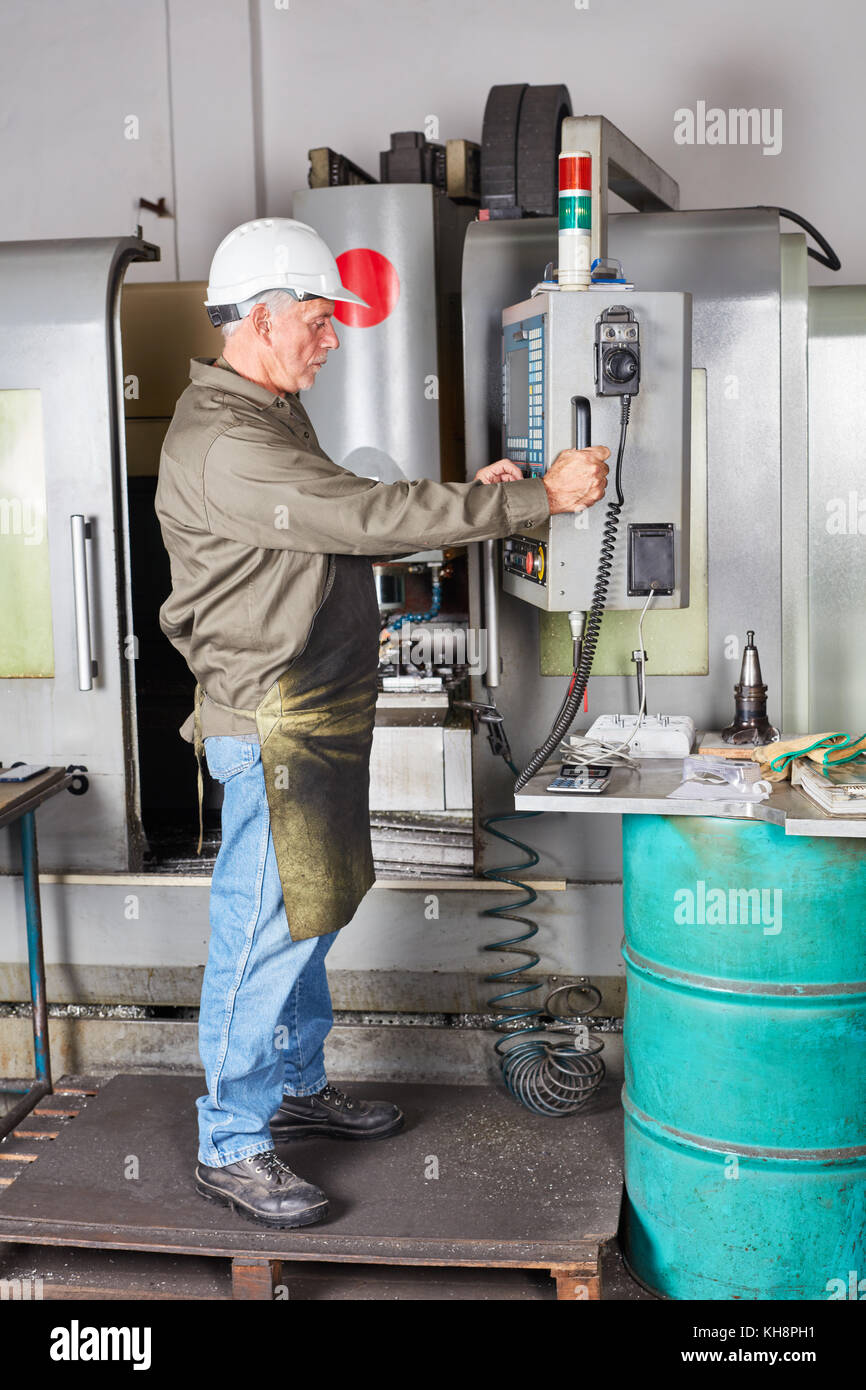 Worker using CNC machine in metallurgy factory Stock Photo - Alamy
